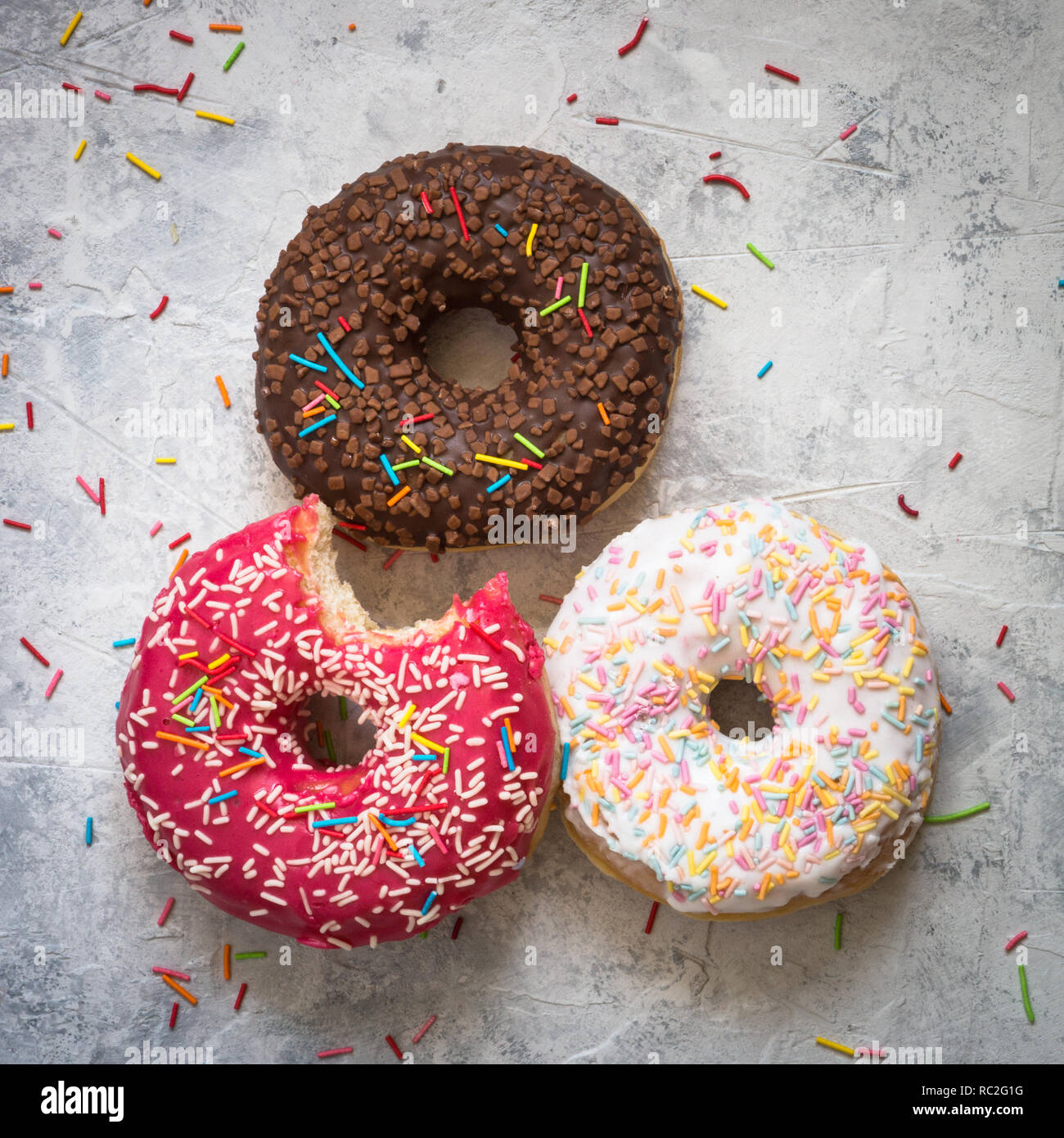 Colorful donuts at concrete table Stock Photo - Alamy