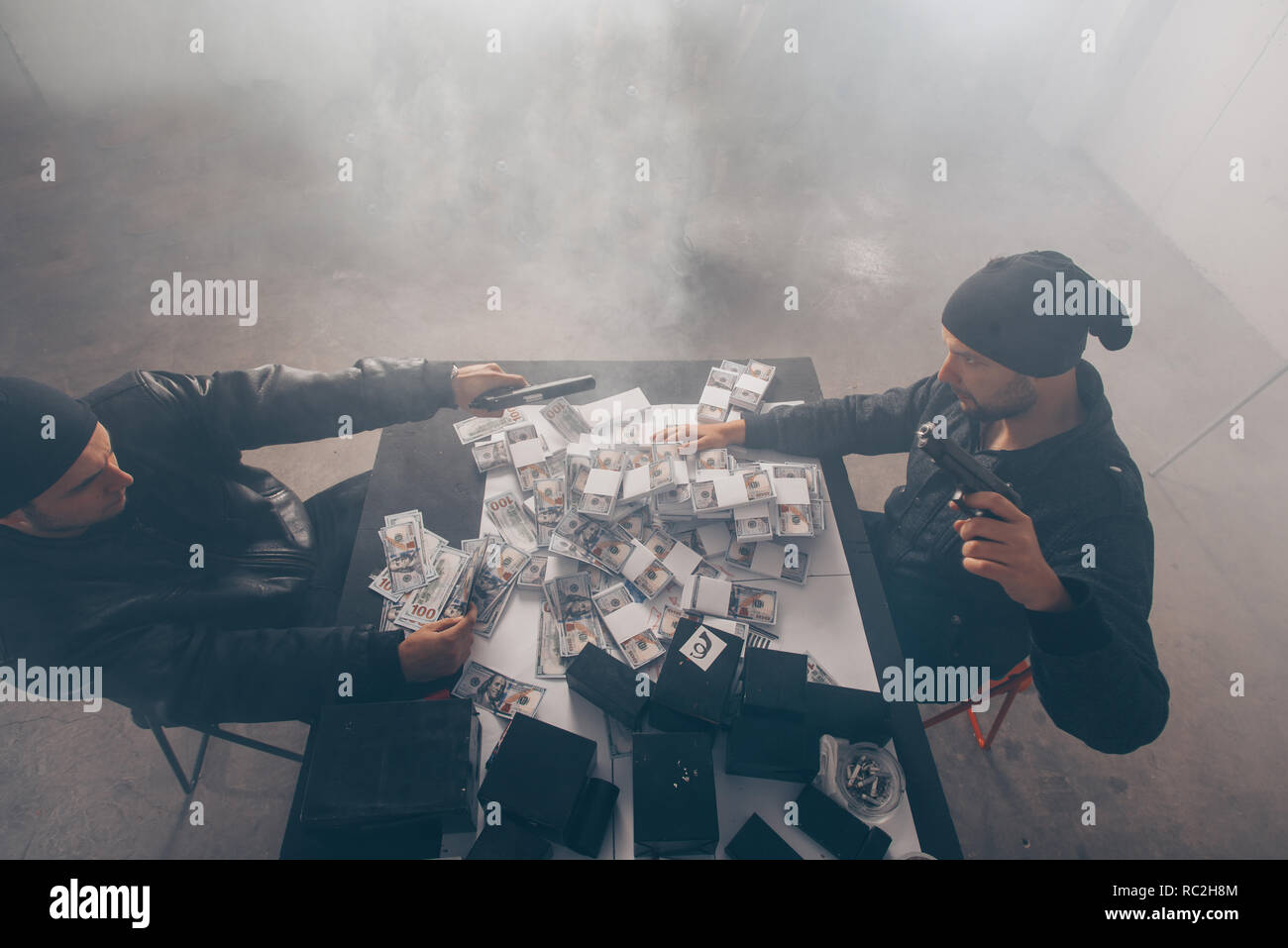 Gangsters are counting money in a smoky room, while they holding a ...