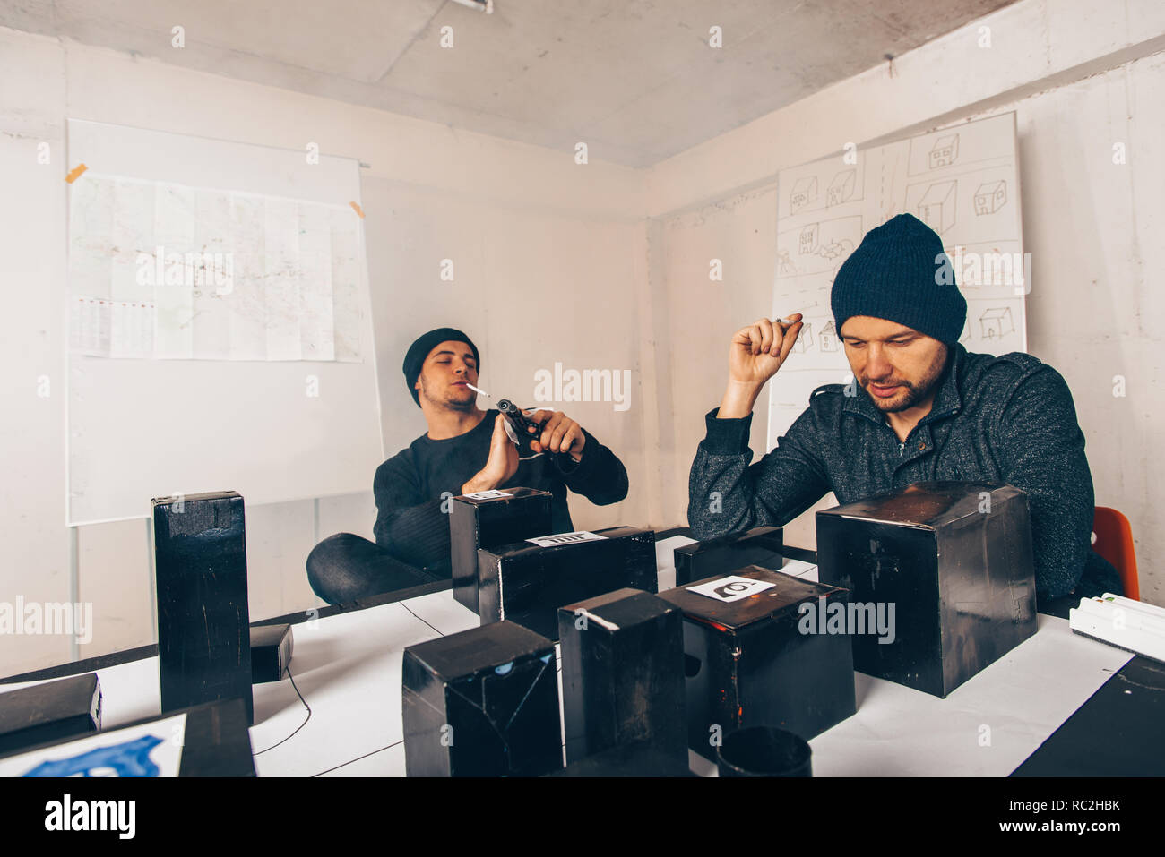 Two men sitting in a room and planning a robbery Stock Photo - Alamy