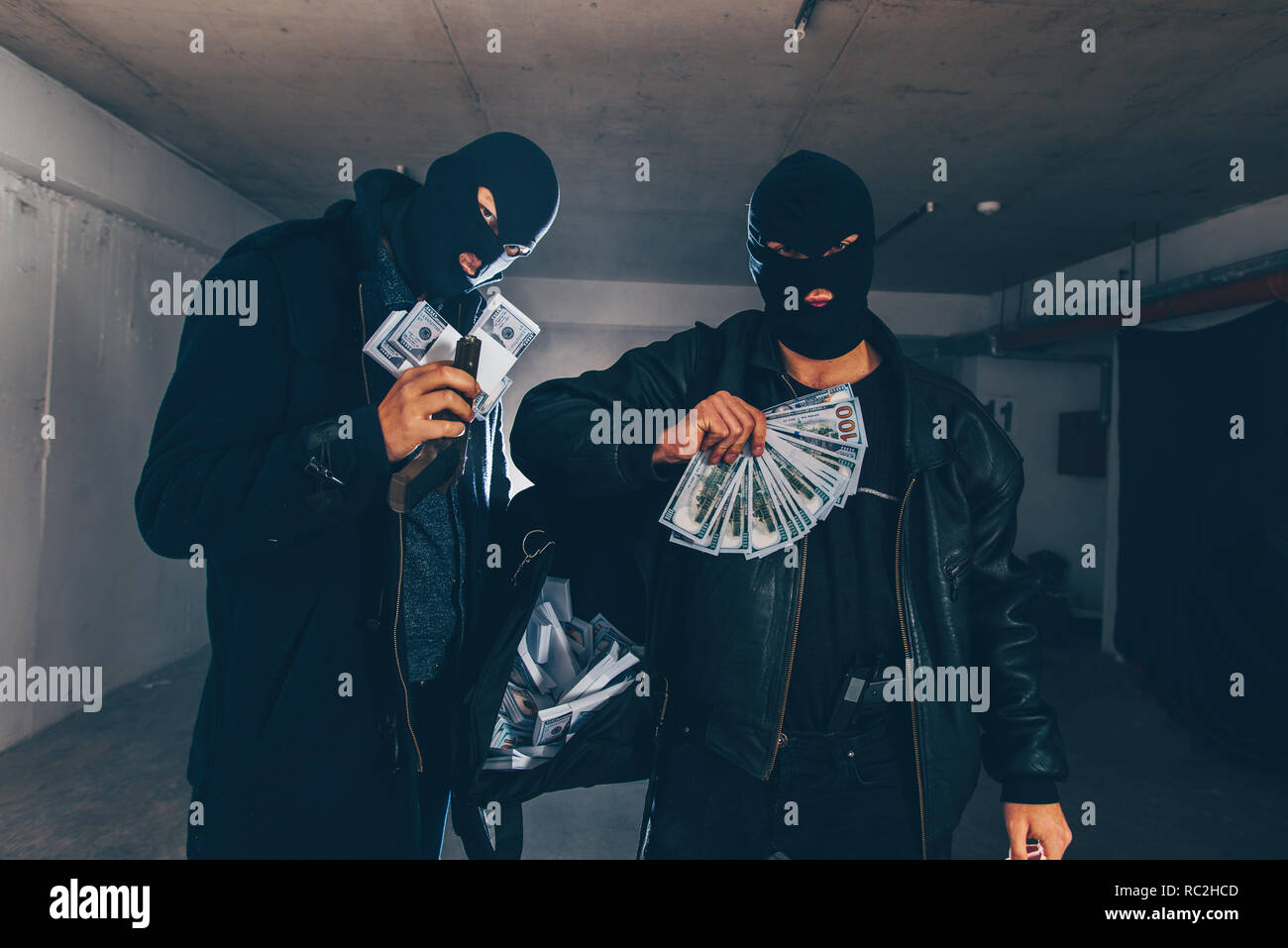 Stealers with masks are standing in a dark room with guns in his hands ...