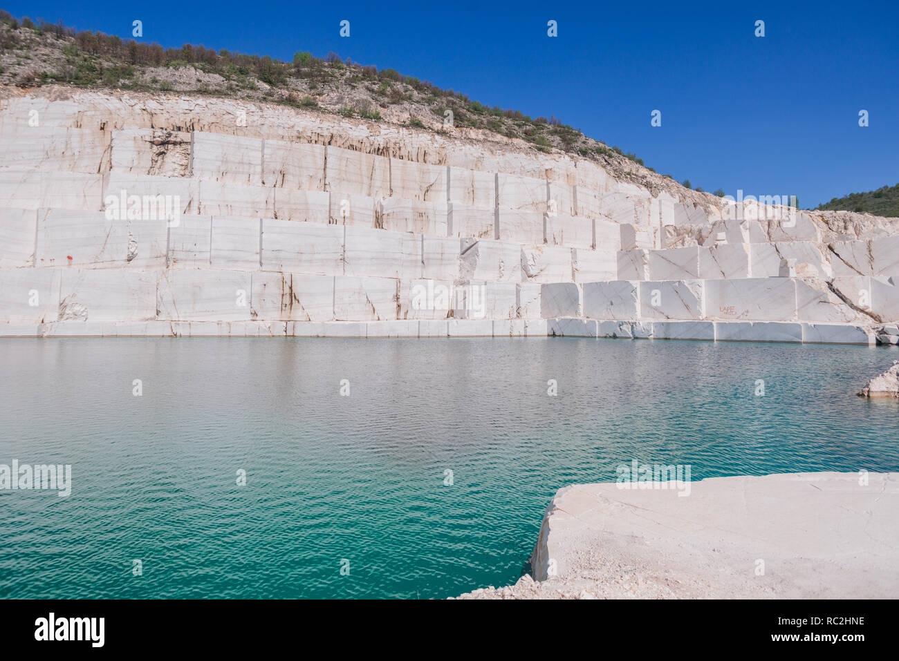 Marble quarry landscape in the mountains with a turquoise lake water ...