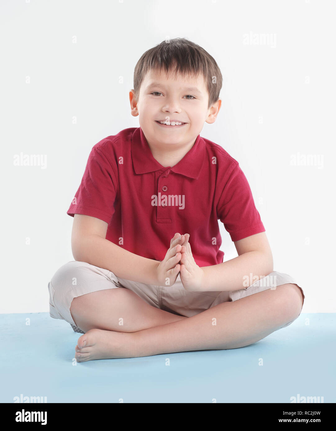 little boy is sitting in the Lotus position.isolated on white Stock ...