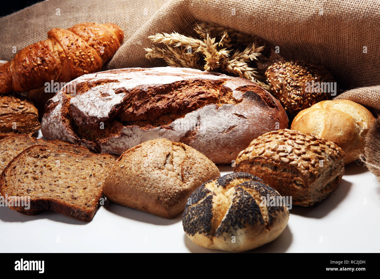 Different kinds of bread and bread rolls on board from above. Kitchen ...