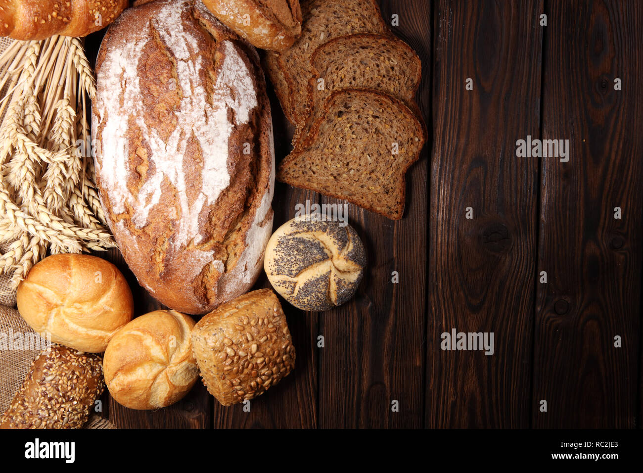 Different kinds of bread and bread rolls on board from above. Kitchen ...