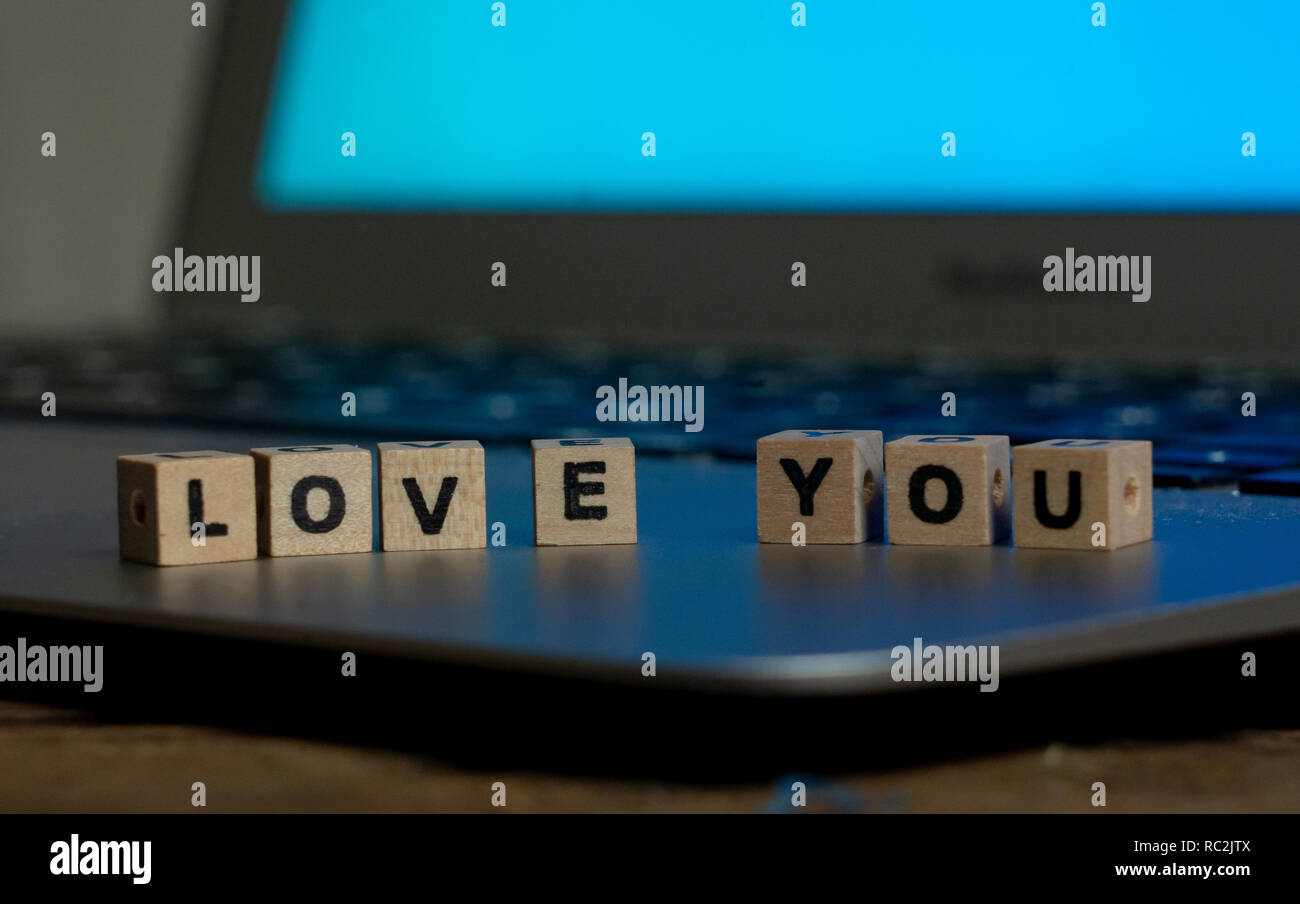 Conceptual image of text Love you in wood blocks on computer with mood ...