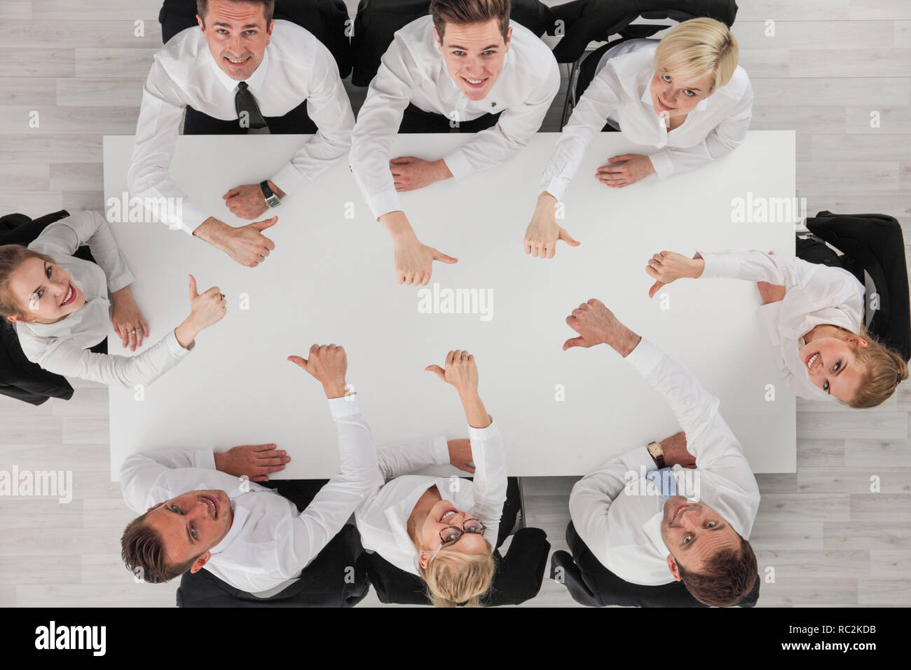 Business people team sitting around white table smiling and showing ...