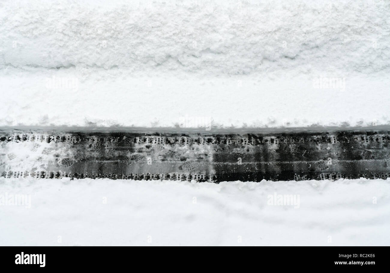 cleared path through deep snow on an asphalt road after a heavy ...