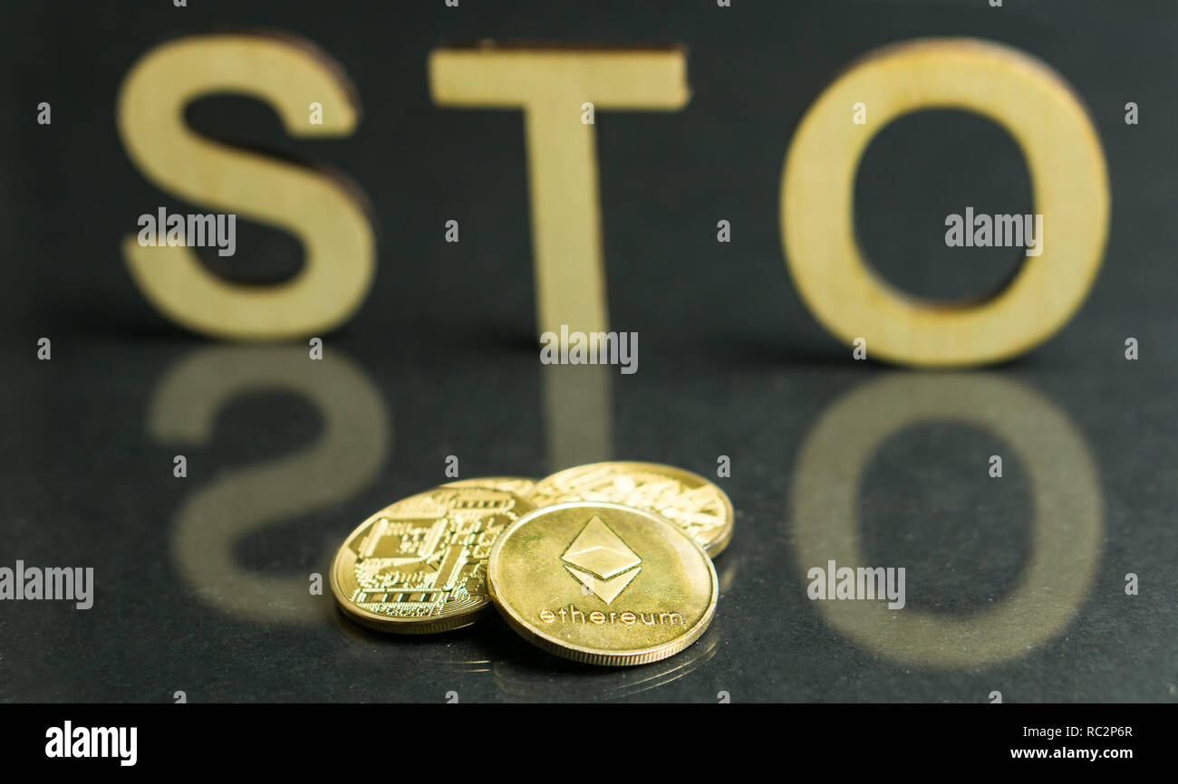Security Token Offering STO sign with wooden letters and gold coins in ...