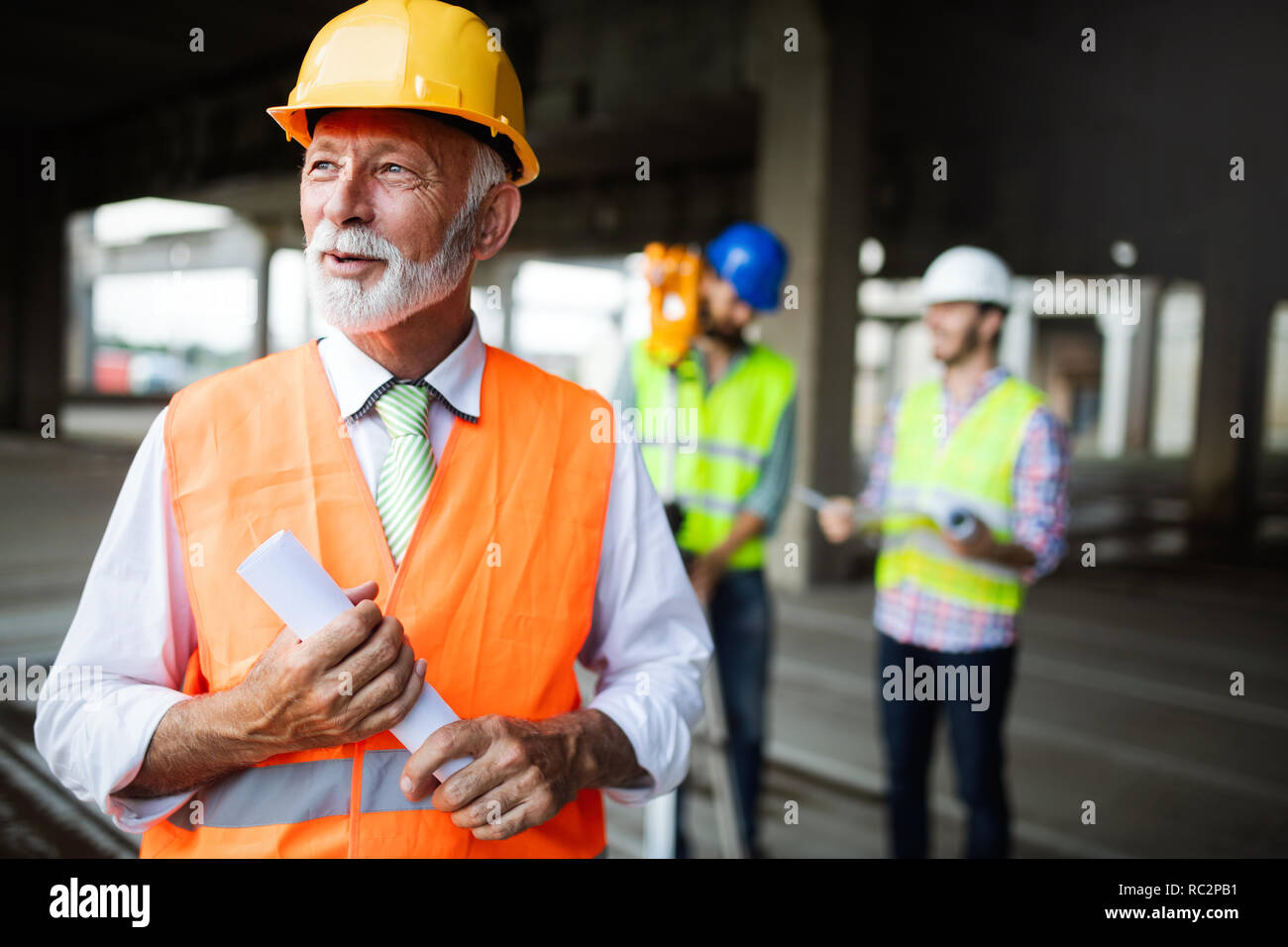 Engineer and construction site manager dealing with blueprints and ...