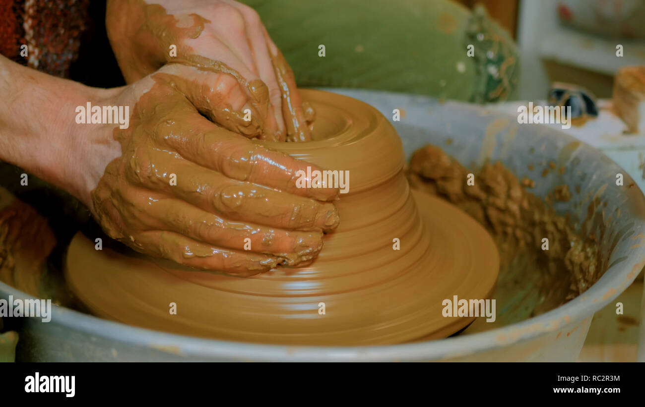Professional male potter making pot in pottery workshop, studio ...