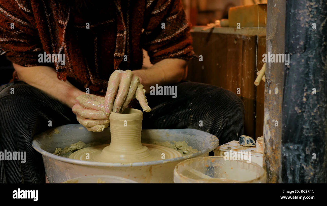 Professional male potter making mug in pottery workshop, studio ...
