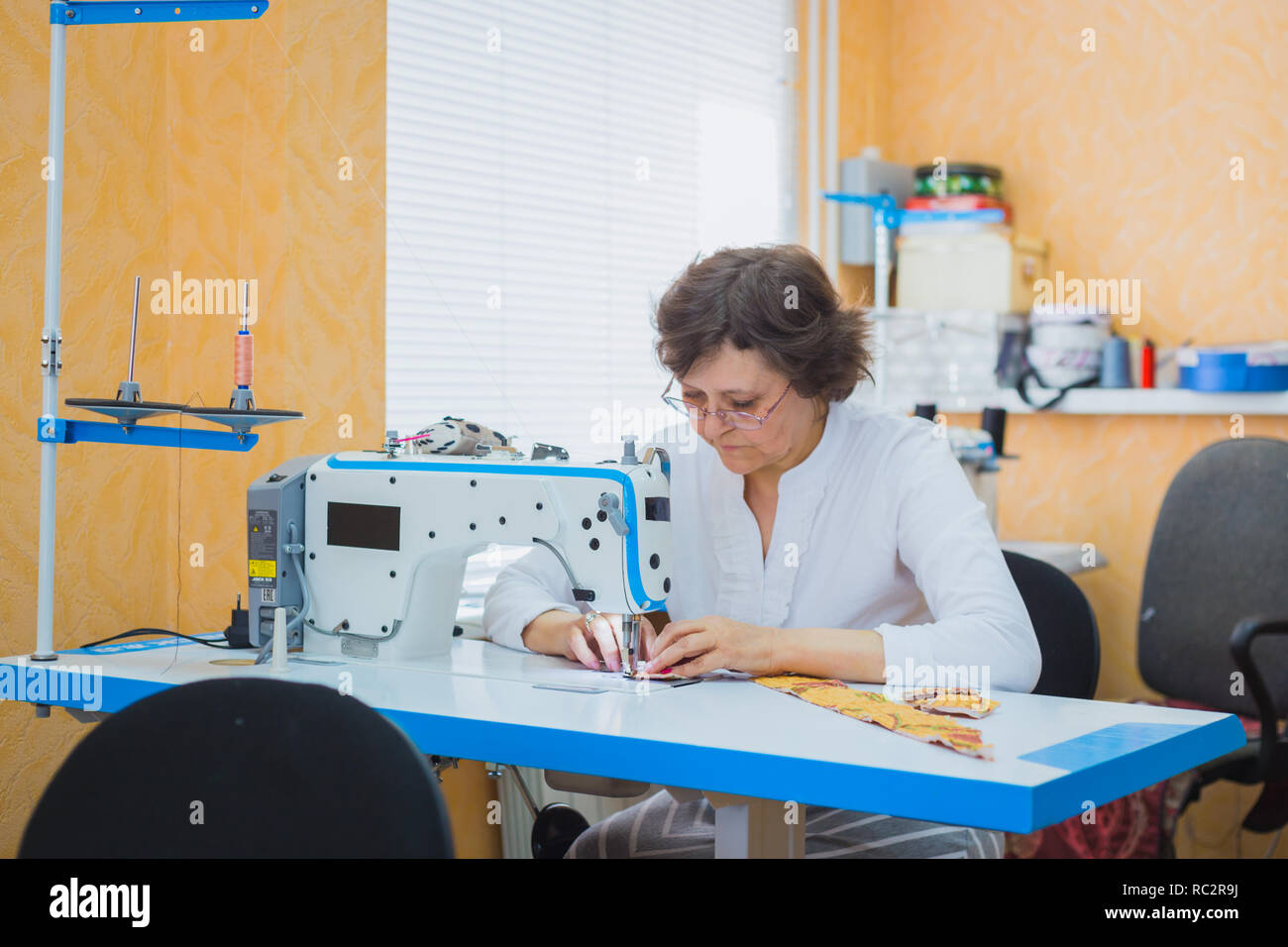Professional tailor, fashion designer sewing clothes with sewing ...
