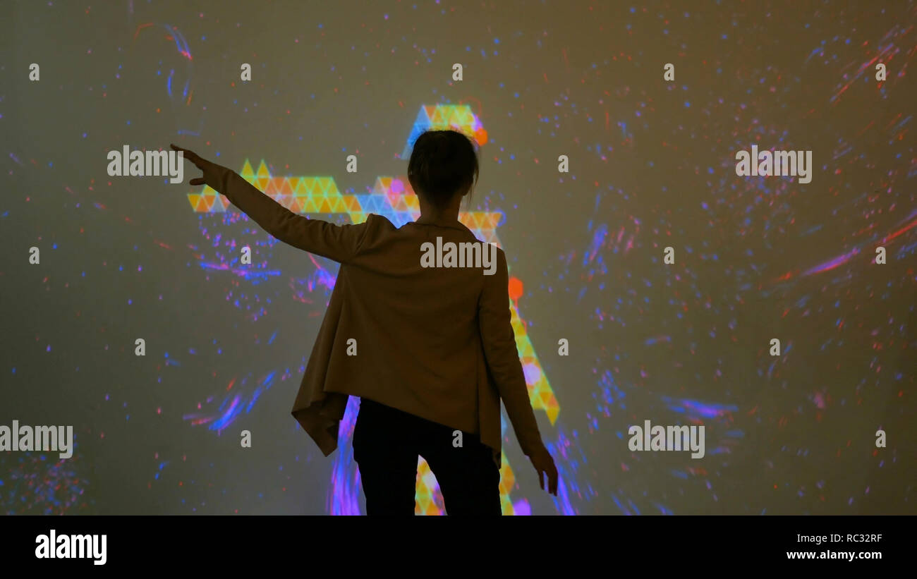 Large screen augmented reality experience - woman moving hands in front ...