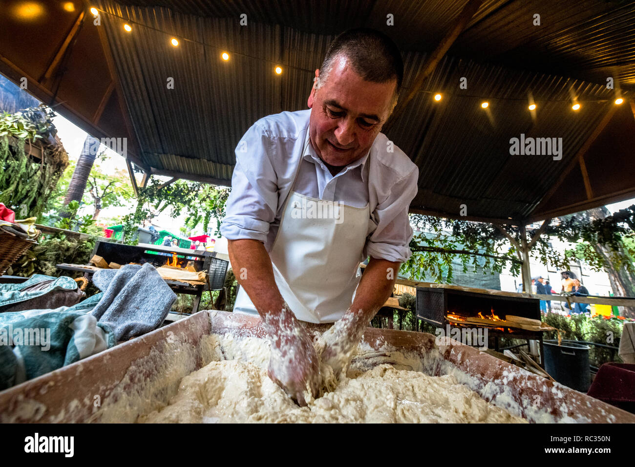 Baker making the traditional Madeira bread, Bolo Do Calco Stock Photo ...