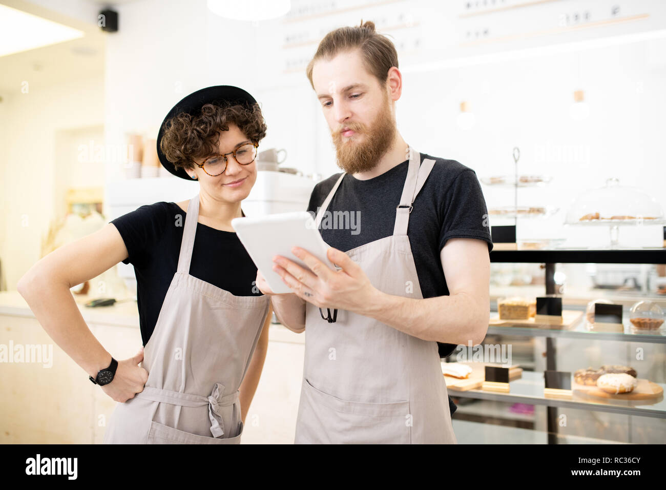 Content young staff of coffee shop checking order on tablet Stock Photo ...