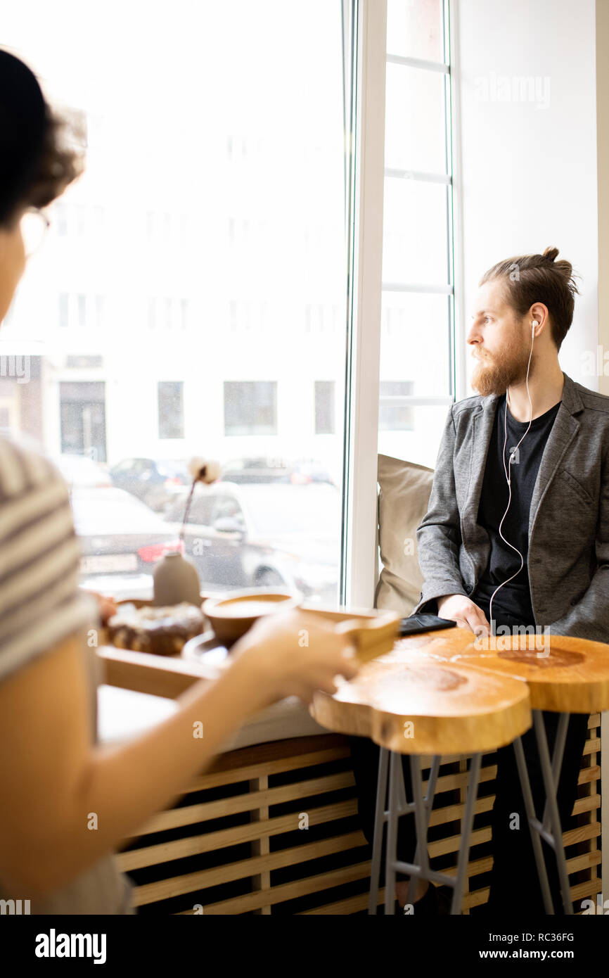 Pensive hipster man looking out window in cafe Stock Photo - Alamy