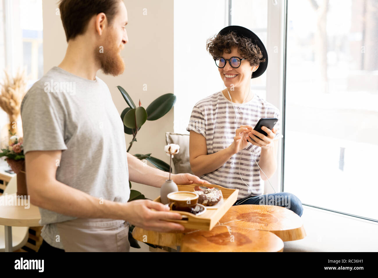 Lady customer smiling at waiter Stock Photo - Alamy
