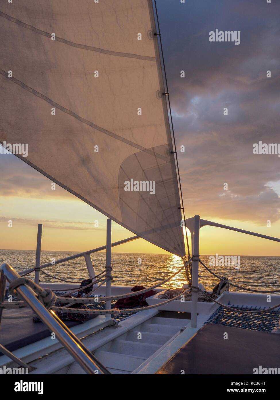 View of a sunset from a catamaran Stock Photo - Alamy
