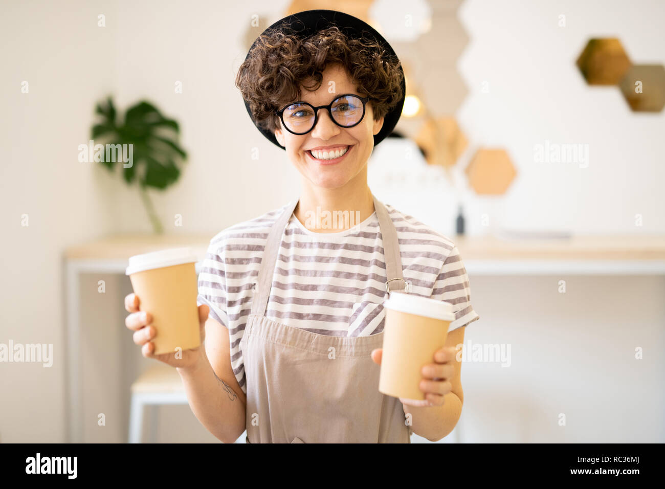 Happy lady barista with disposable coffee cups Stock Photo - Alamy