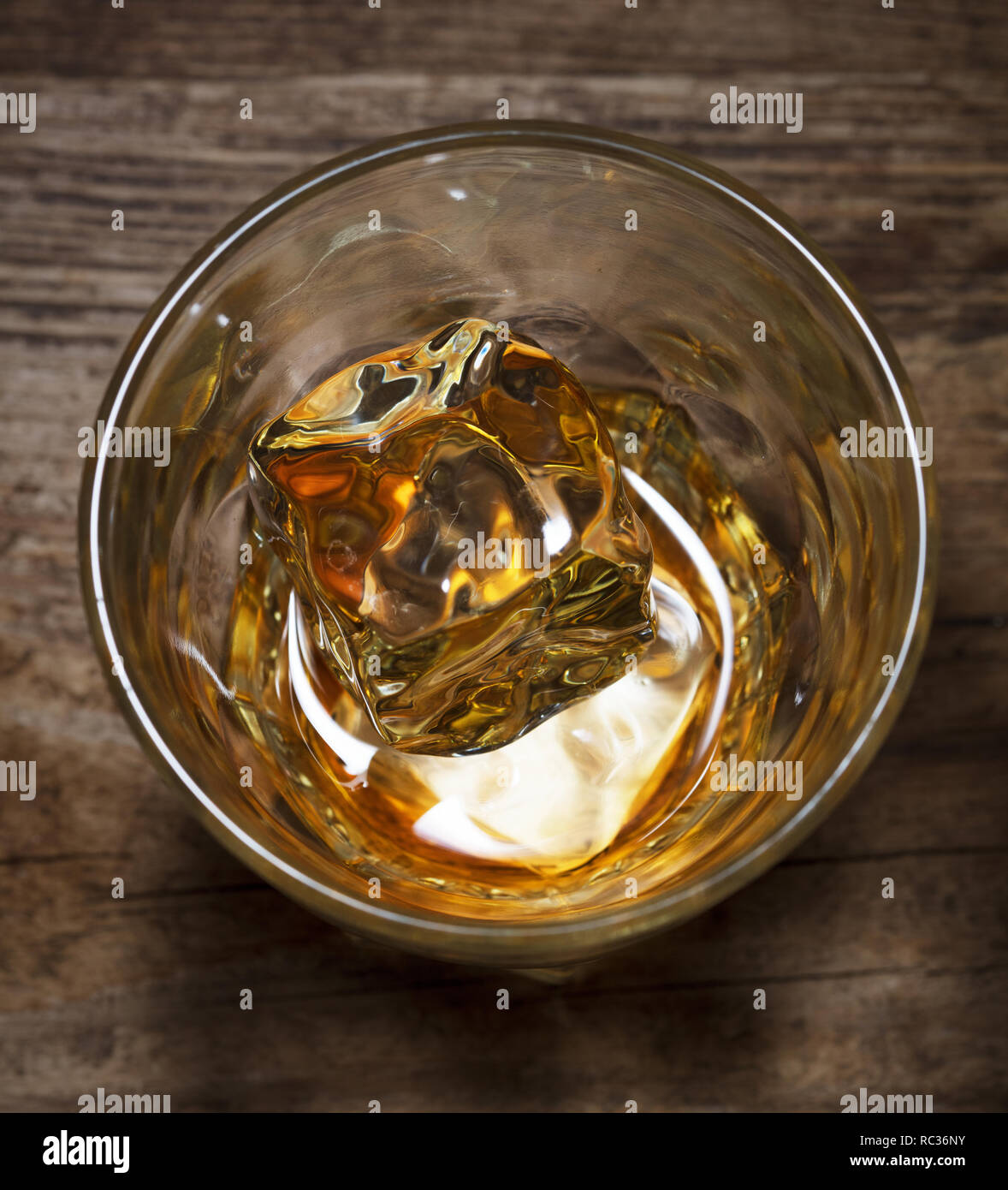 top view of single glass of alcohol drink with ice on wooden background ...