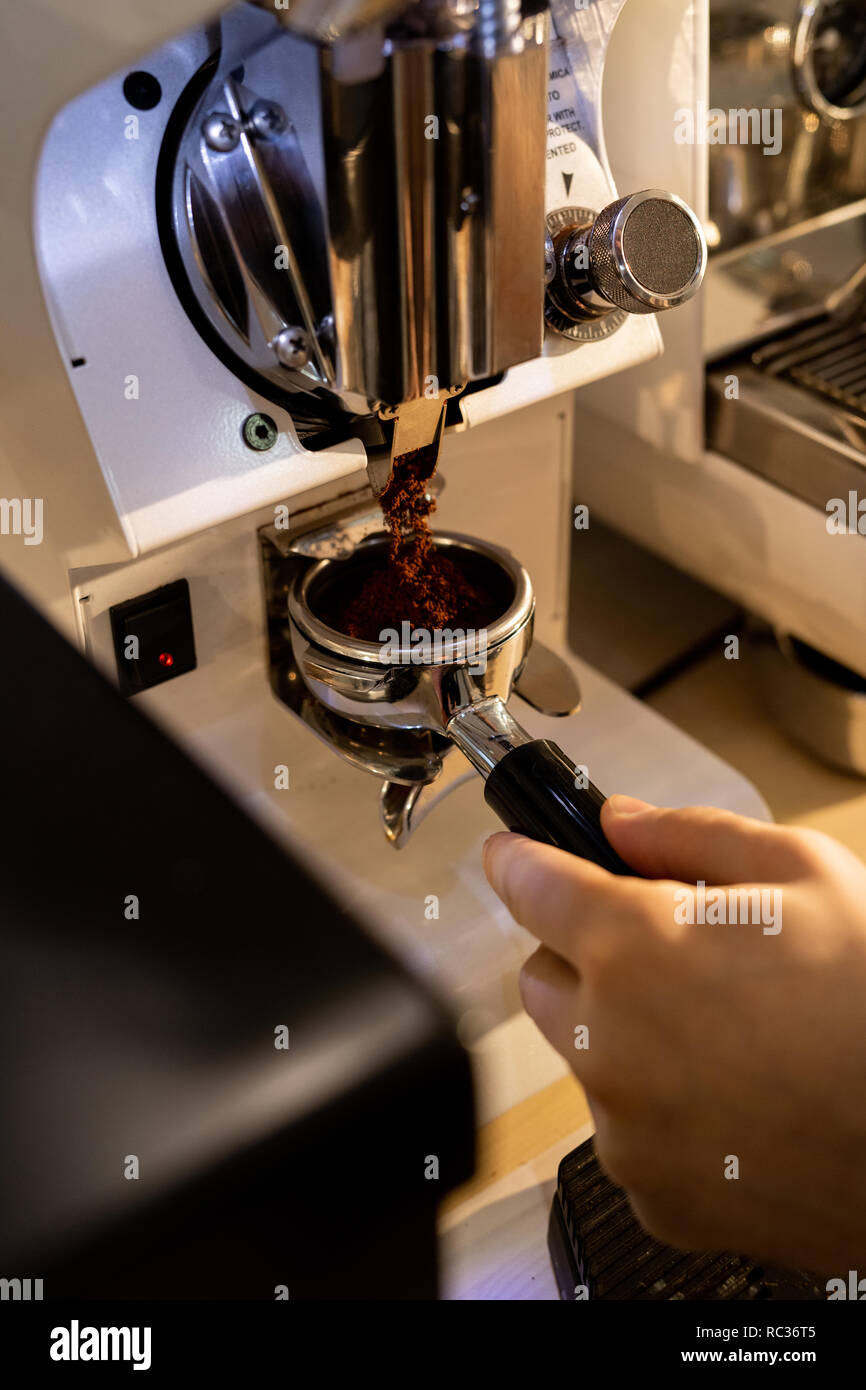 Barista grinding coffee beans Stock Photo - Alamy
