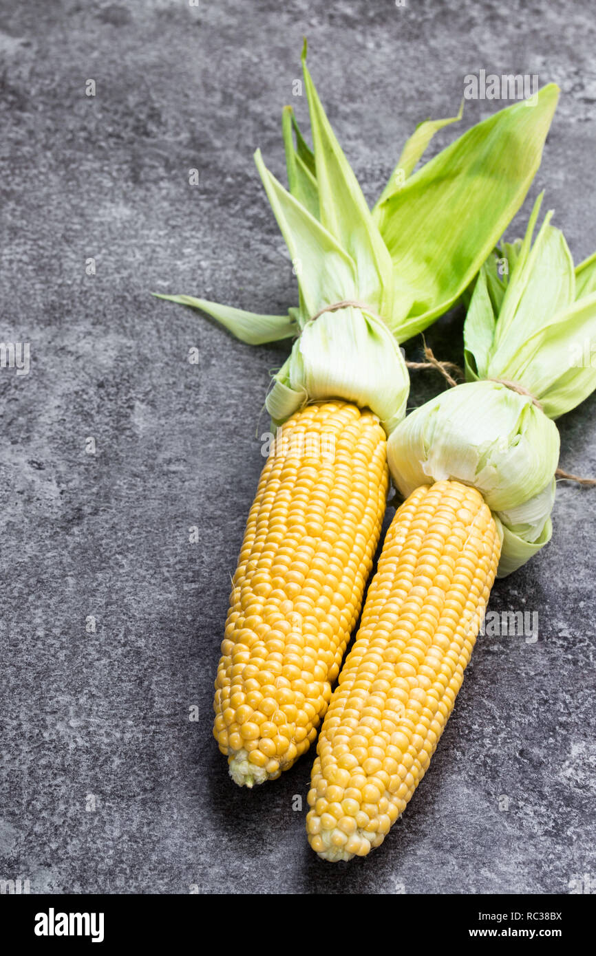 Raw corn on cobs on grey table Stock Photo - Alamy