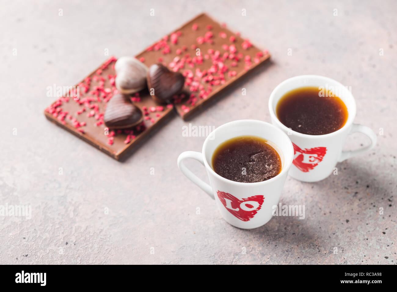 Two Cup of coffee with love and chocolate candies in a heart shape over ...