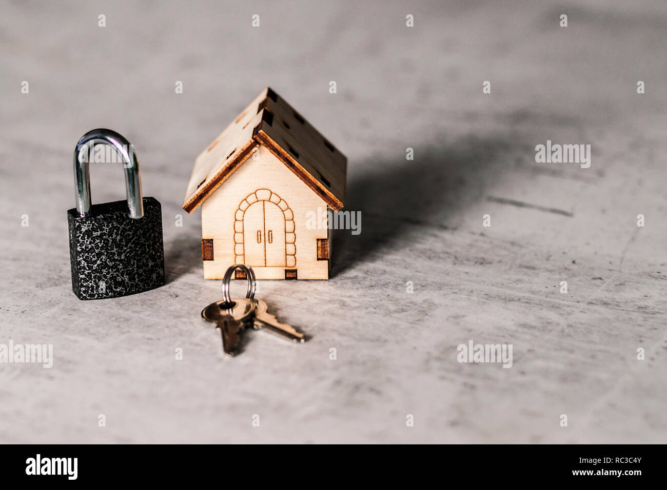 Model of a wooden house with a lock and keys on a gray background ...