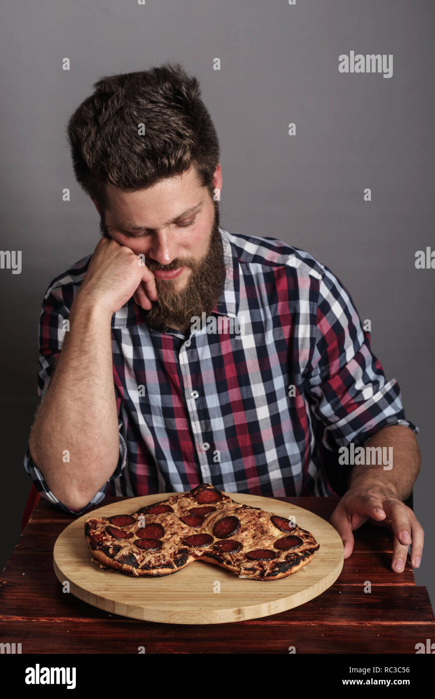 Sad man looking at fail burned heart shaped pizza Stock Photo - Alamy