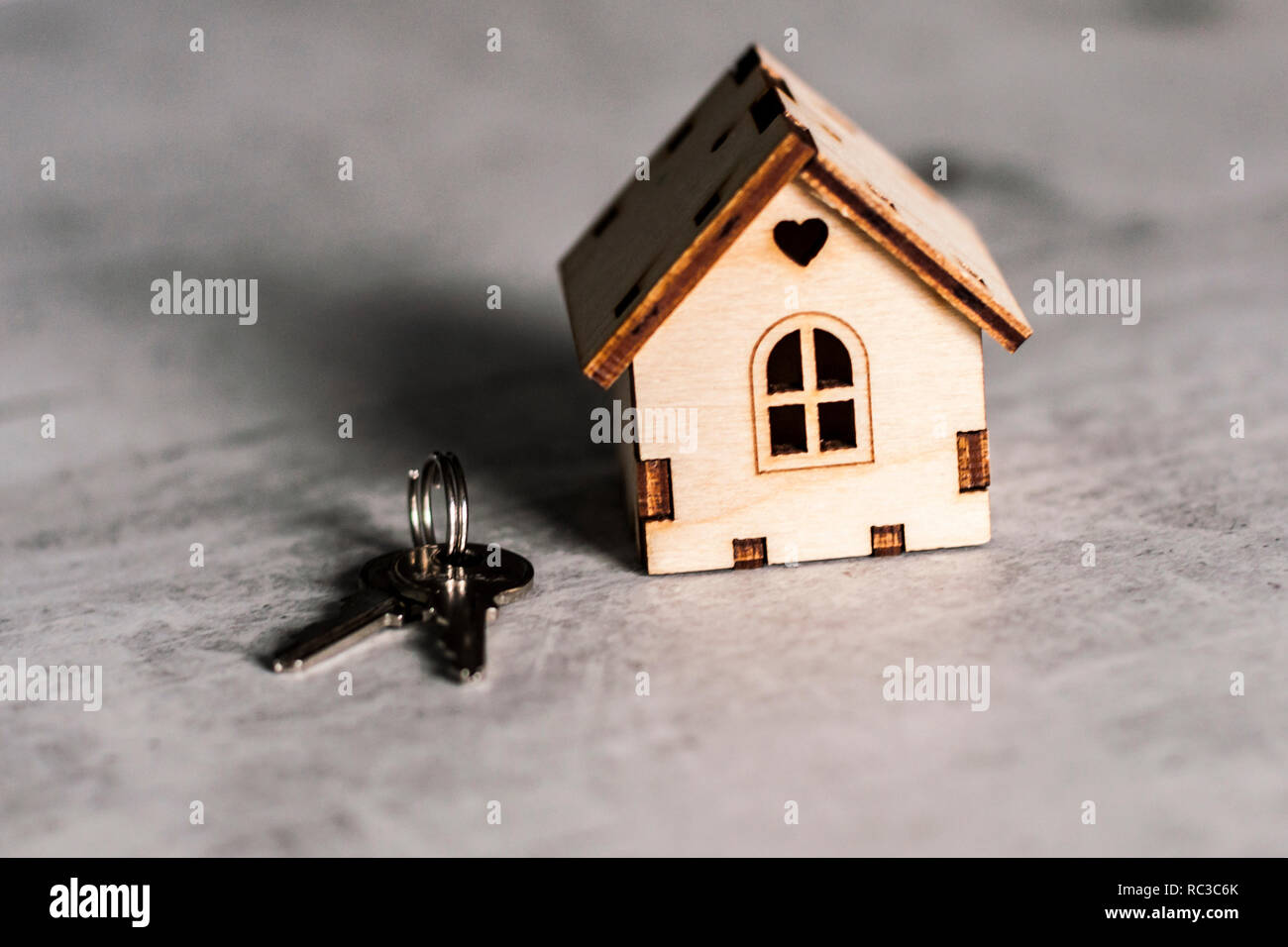Model of a wooden house with a lock and keys on a gray background ...