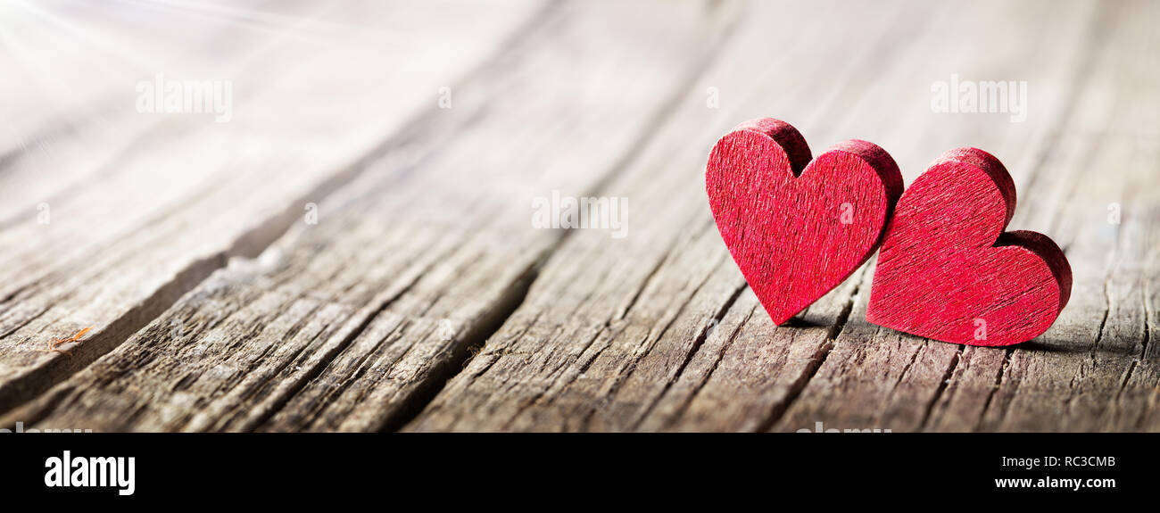 Two Wooden Hearts On Rustic Table With Sunlight Stock Photo - Alamy