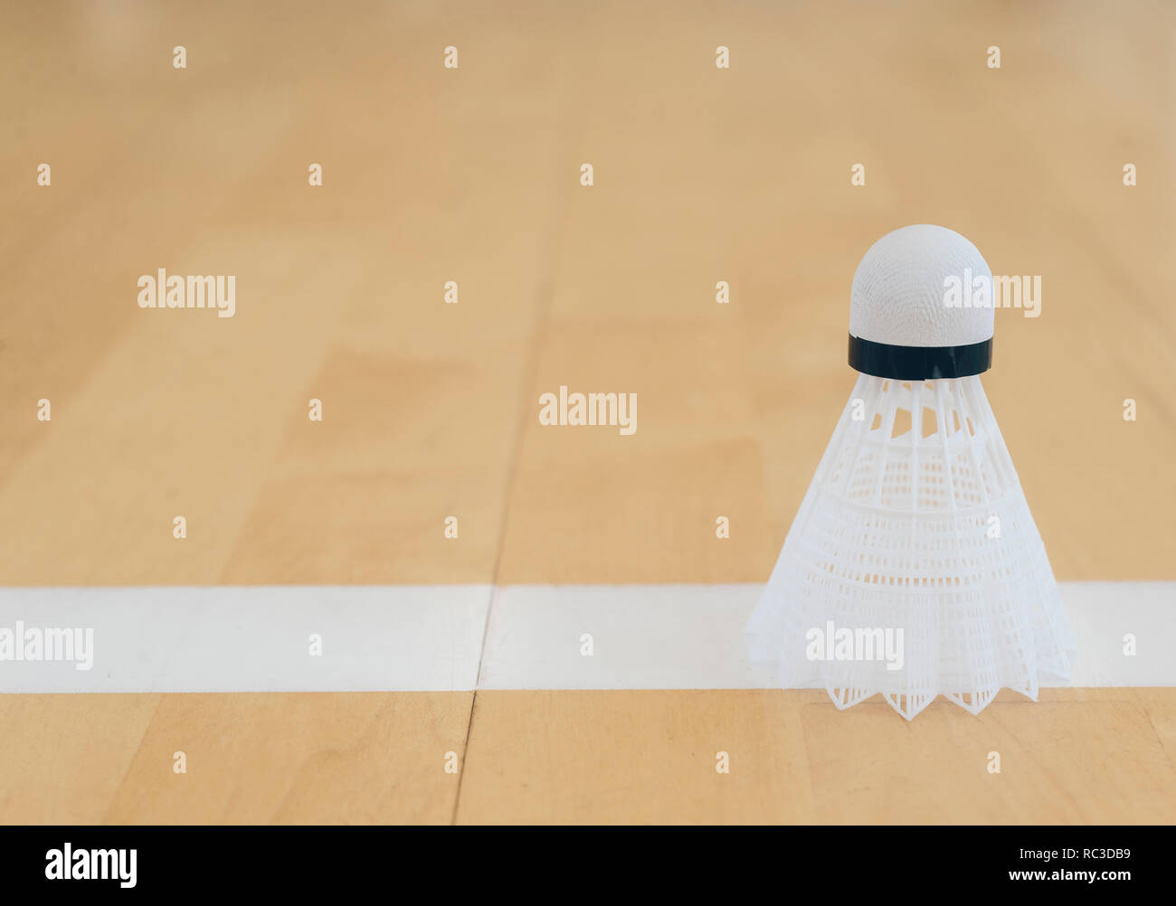 White badminton shuttlecock on a line hall floor at badminton courts ...