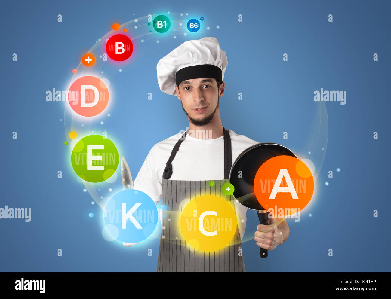 Handsome cook with kitchen instruments and vitamin concept Stock Photo ...