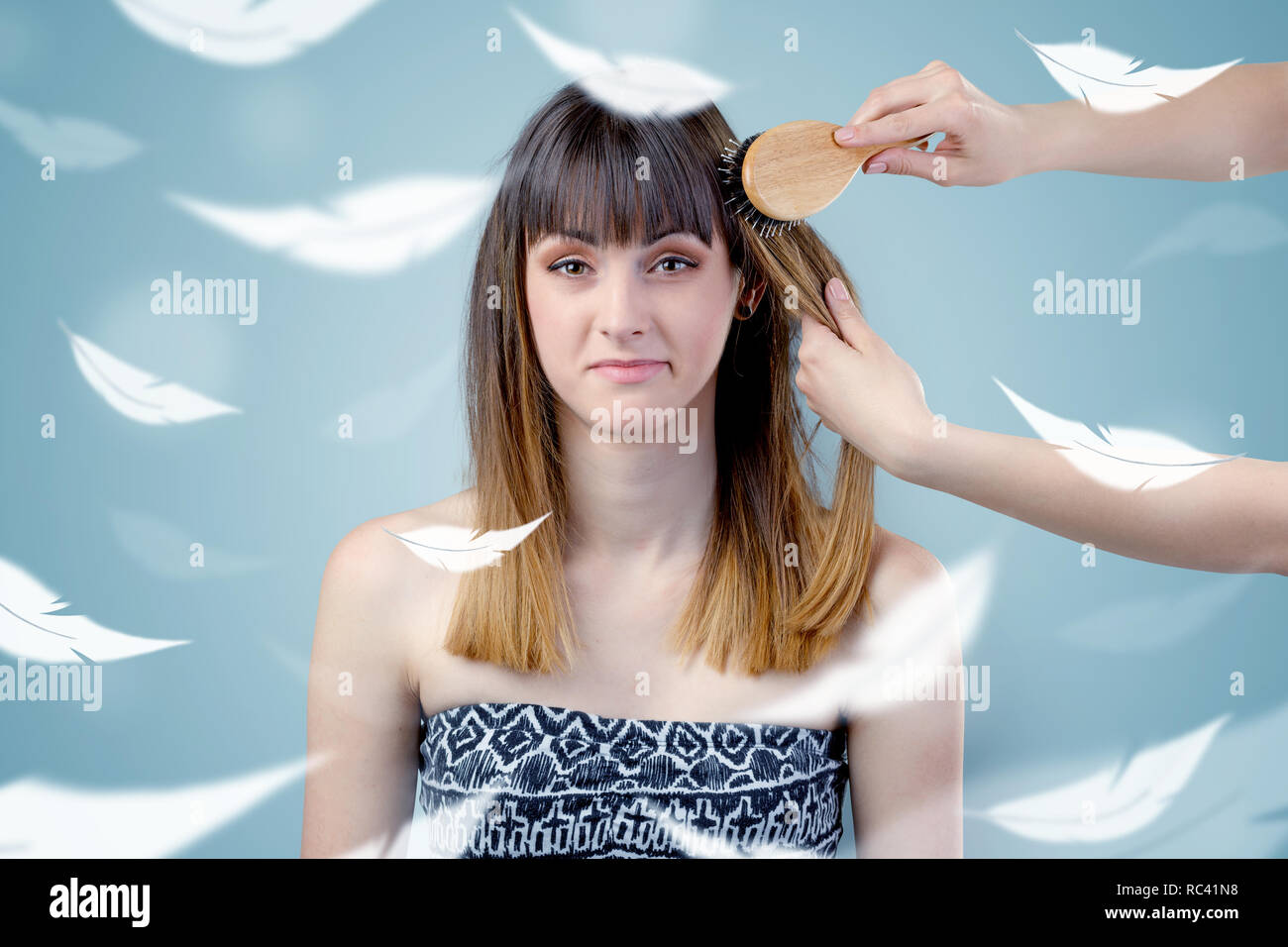 Pretty brunette woman at salon with plume around and ethereal concept ...