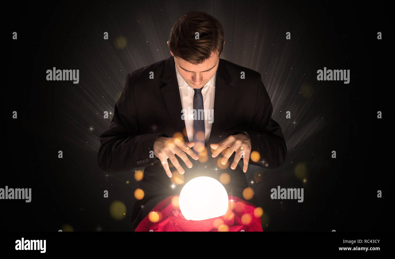 Gorgeous businessman sitting with sparkling magic ball in his lap Stock ...