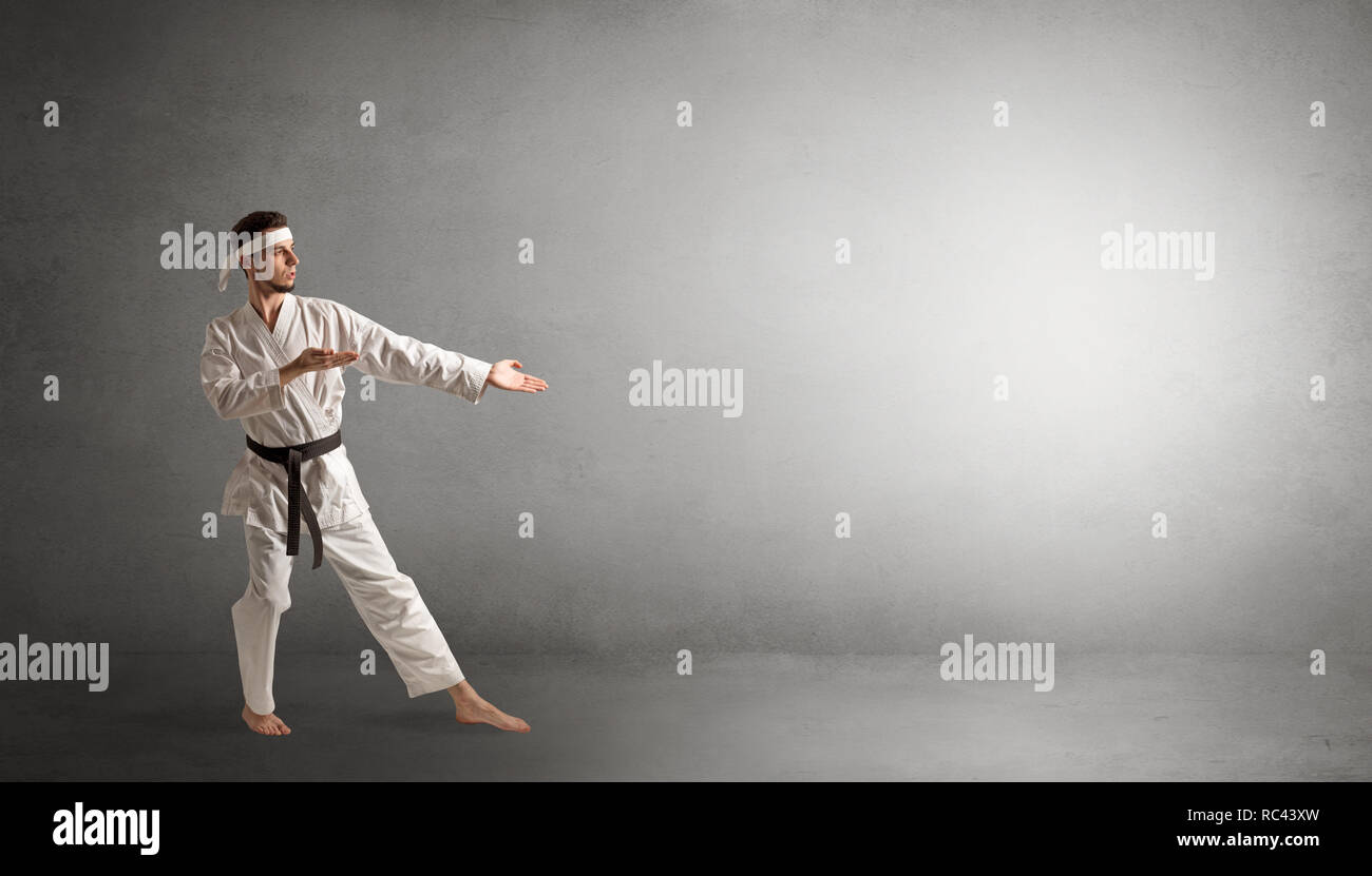 Small karate man fighting in an empty grey copy space Stock Photo - Alamy