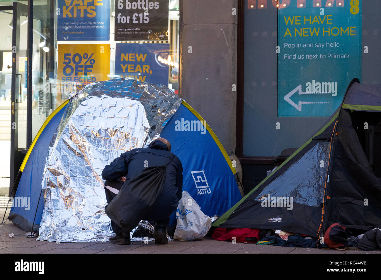 Tents used by the homeless in front of an empty, closed down, boarded ...