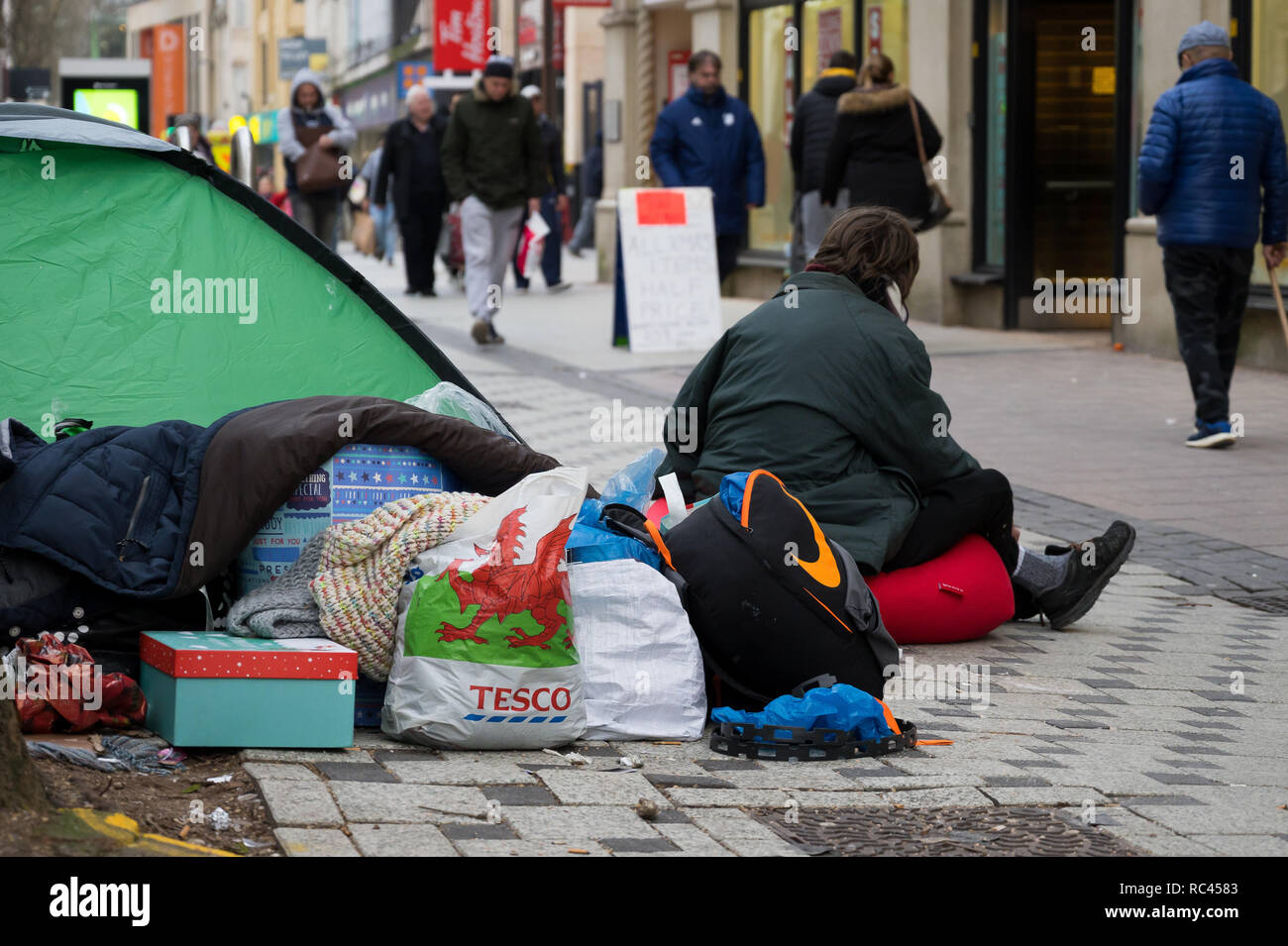 A homeless man sits on the floor next to a tent on Queen Street in ...