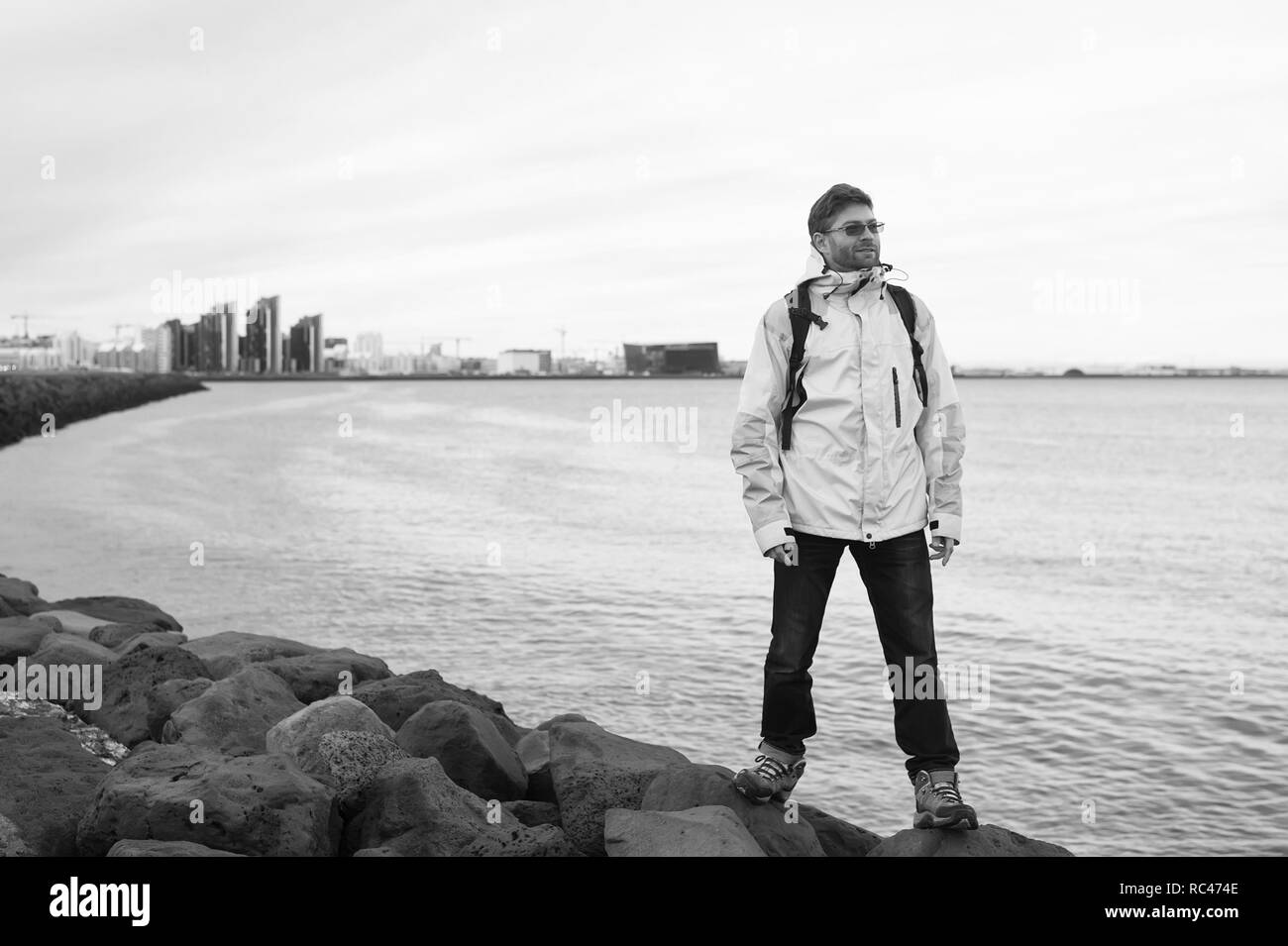 inspired man on sea beach in reykjavik, iceland. Man traveler smile and ...