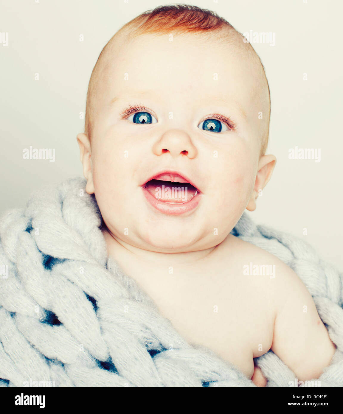 little cute red head baby in scarf all over him close up isolate Stock ...