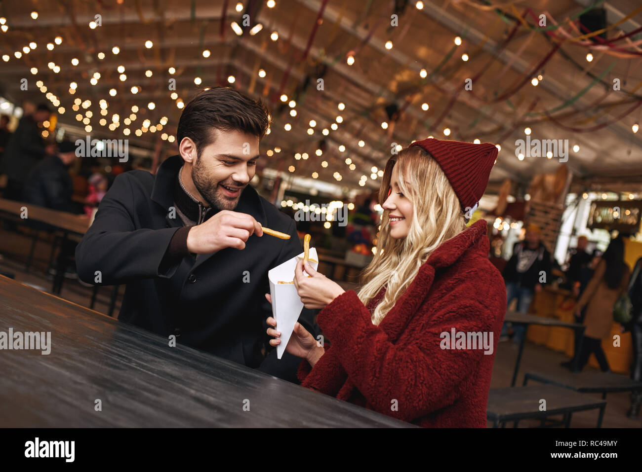 One french fries for two. Young couple are eating french fries at the ...