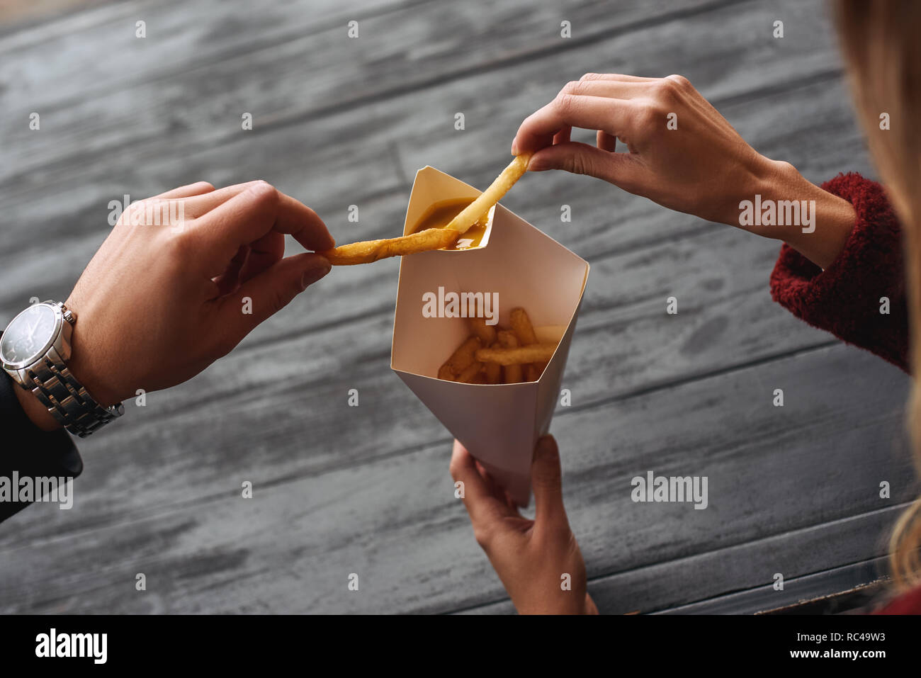One french fries for two. Young couple are eating french fries at the ...