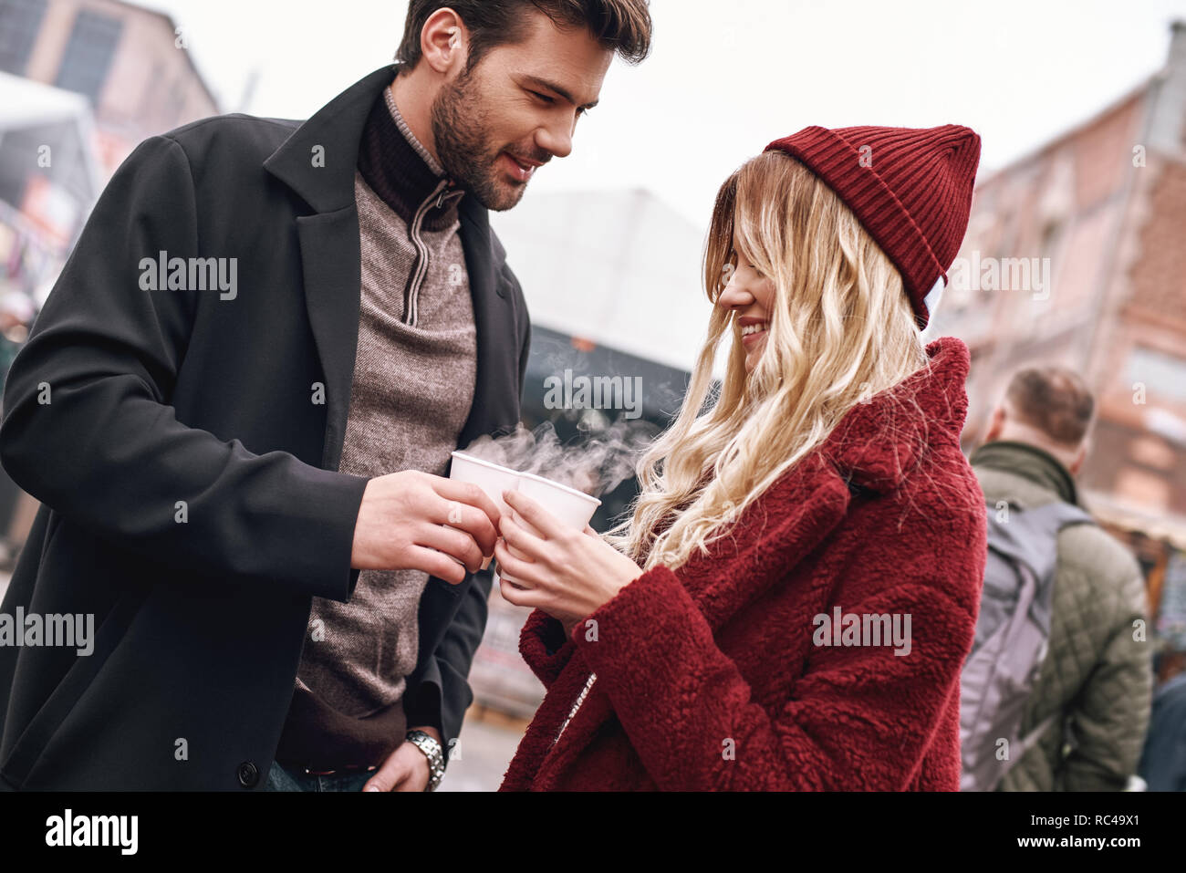 Two cups together. Young couple are drinking hot beverage while ...