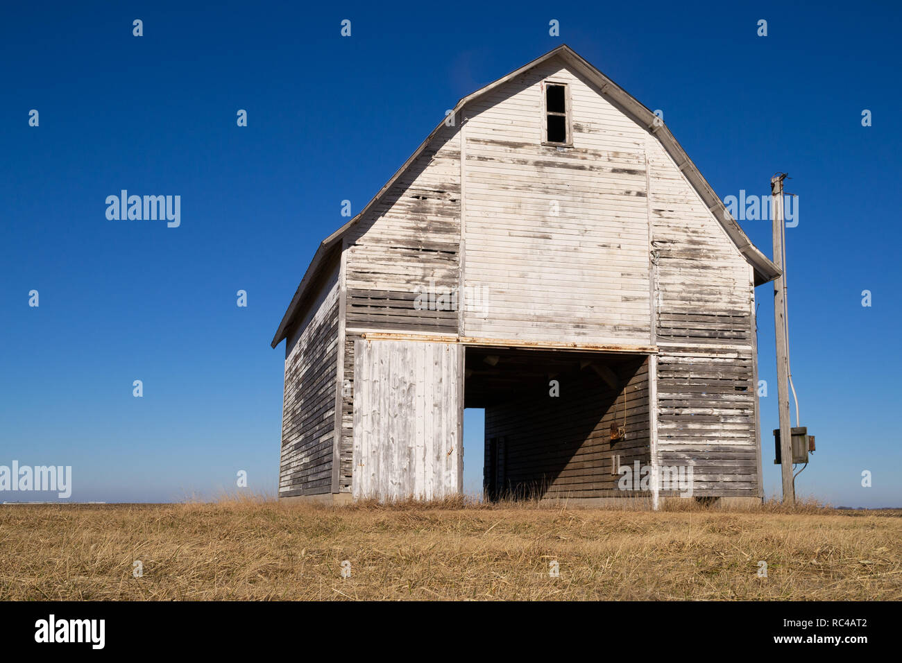 The old white barn in the rural countryside in the late afternoon light ...