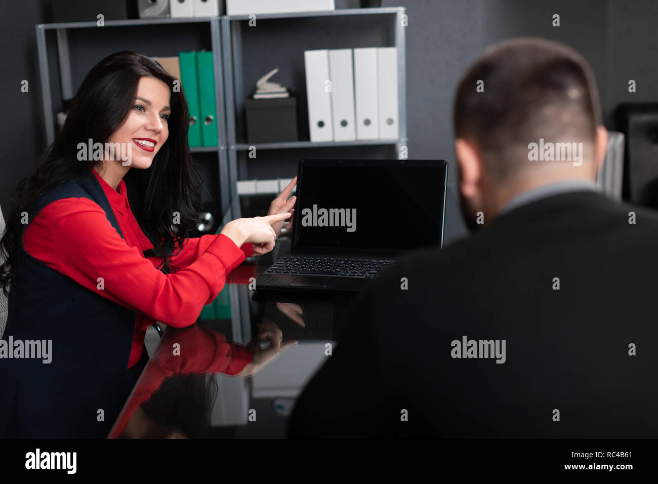 Business people look at blank laptop screen at meeting in stylish ...