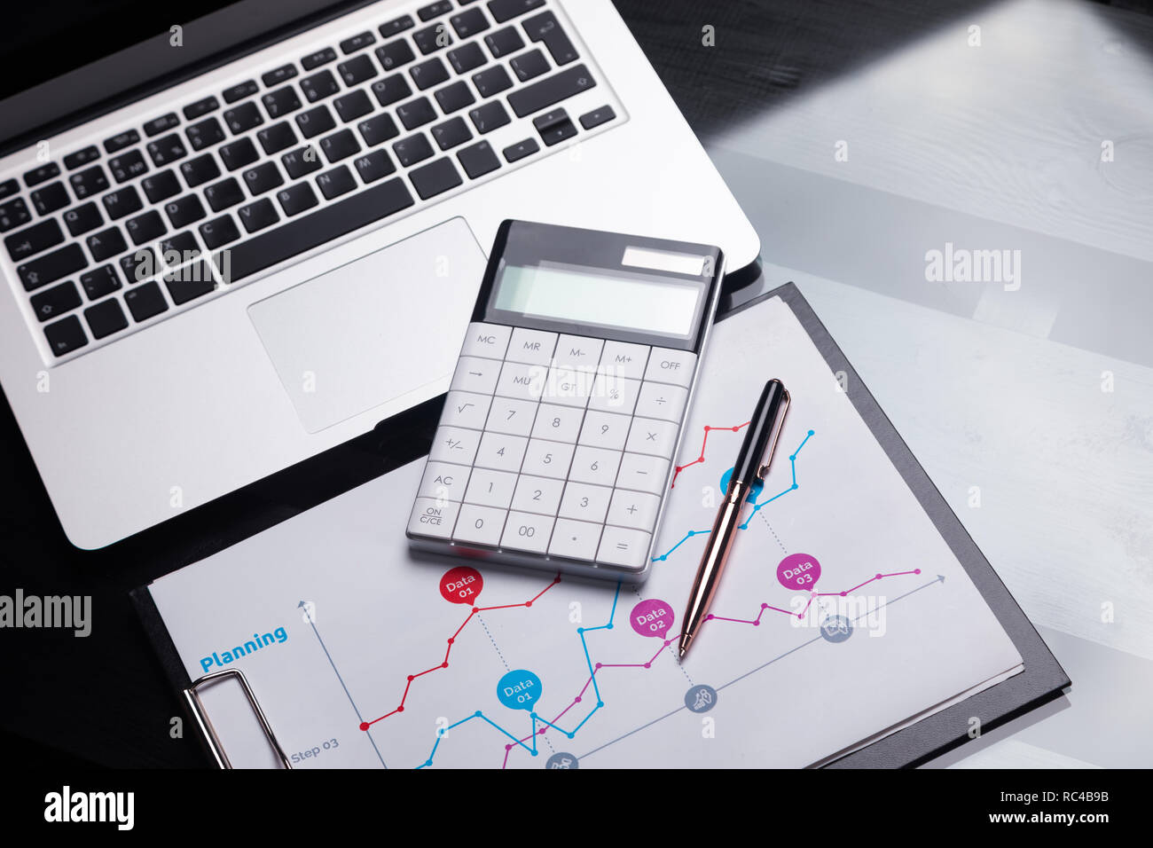 Modern calculator is on a laptop and on a sheet with a graph Stock ...
