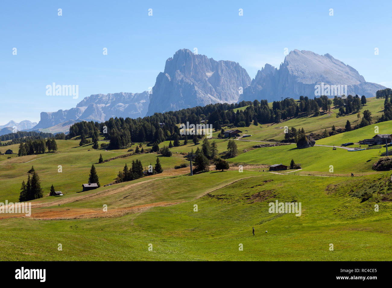 View of an Alpine landscape. Meadows, hills and mountain. Buildings in ...