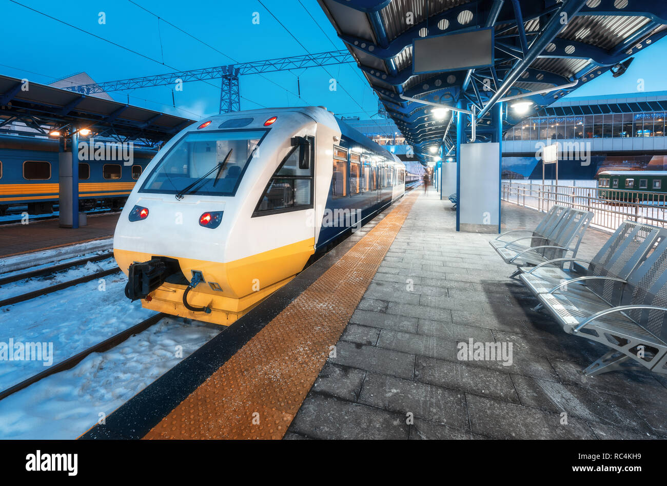 High speed train on the railway station at night in Europe. Urban ...