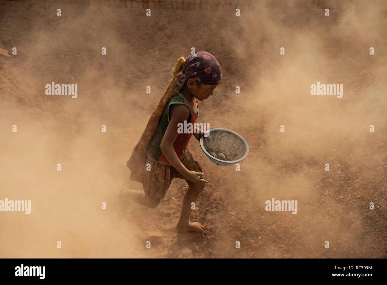 A child seen collecting pieces of coal in a dusty wastage at the brick ...