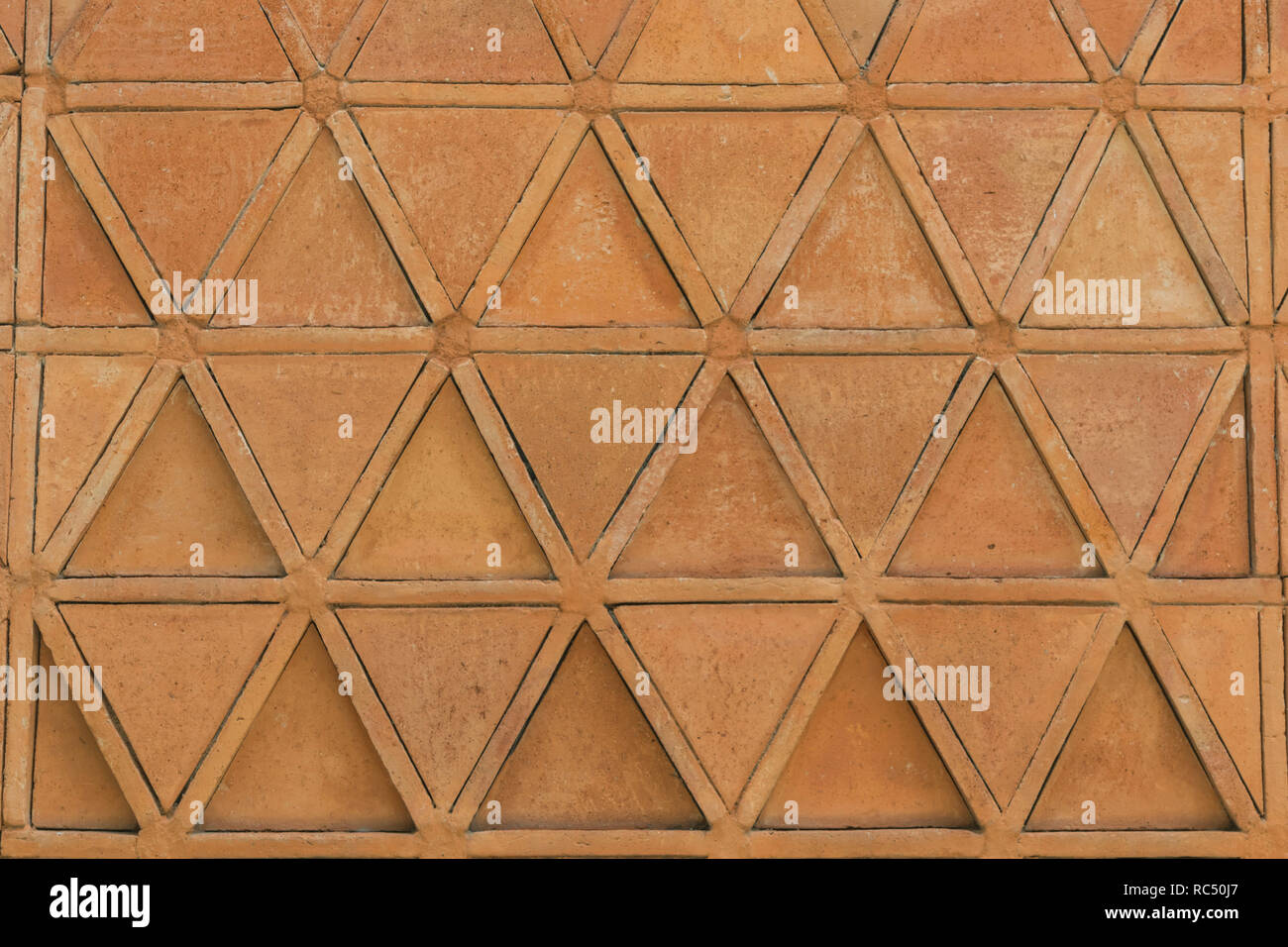 Isolated shot of a red stone wall with a triangular pattern, in Oaxaca ...